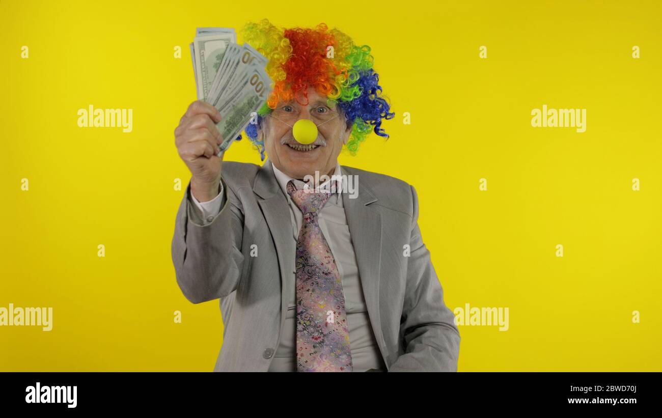 Senior clown director office worker in wig and business suit at work ...