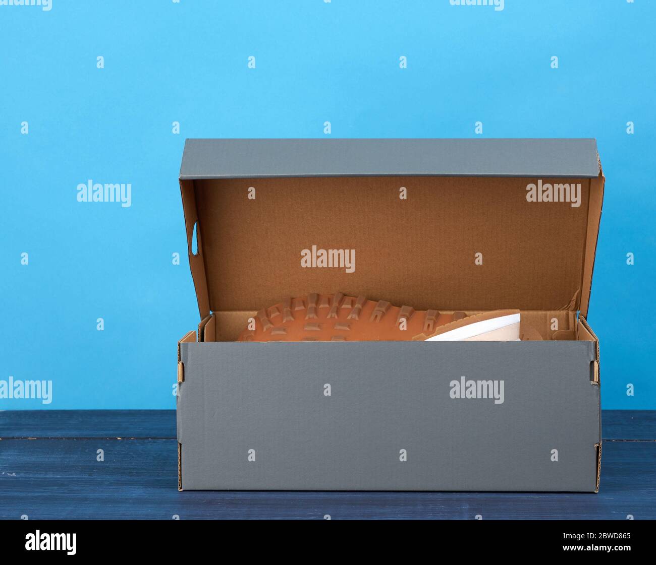 pair of leather sneakers in a gray cardboard box, blue background Stock ...