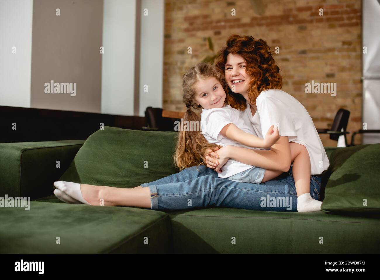 happy daughter hugging cheerful and curly mother Stock Photo - Alamy