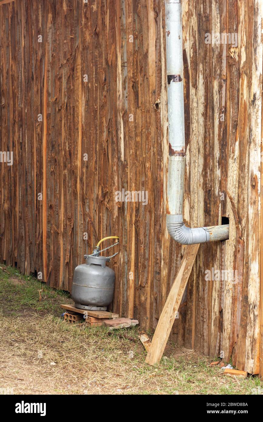 Simple installation of gas canister outside humble wood and chimney for ...