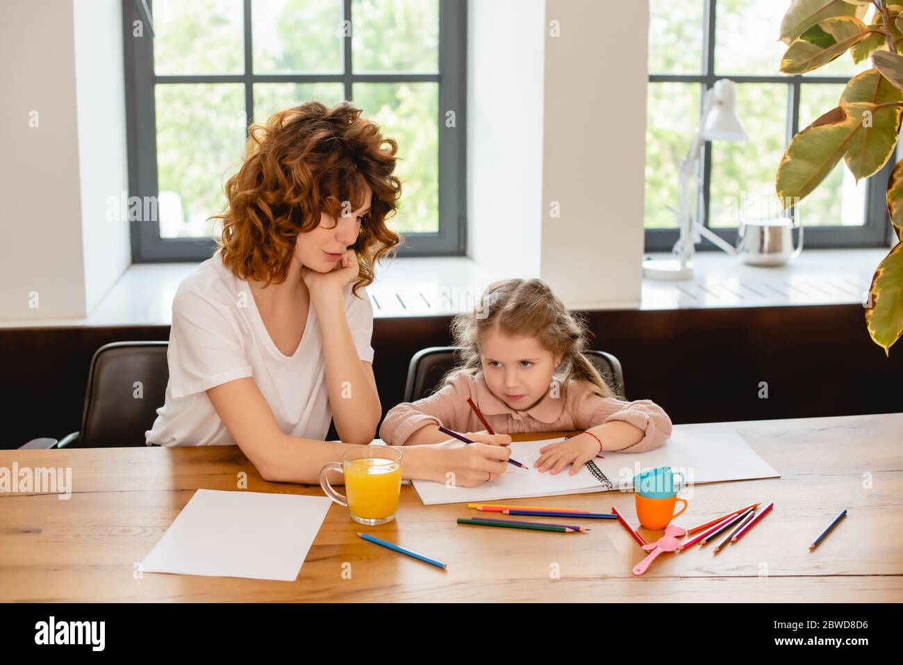 curly mother drawing with adorable daughter at home Stock Photo - Alamy