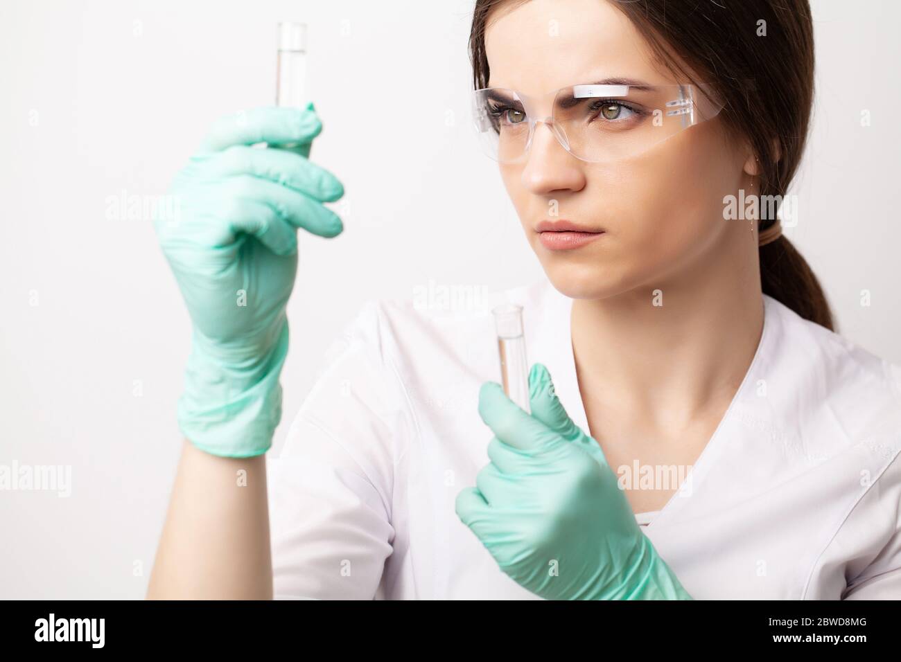 Female doctor in laboratory holding holding test tubes with ...