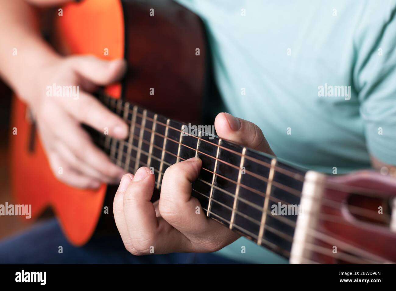 playing the acoustic guitar close-up, hand grips the chord, playing a ...