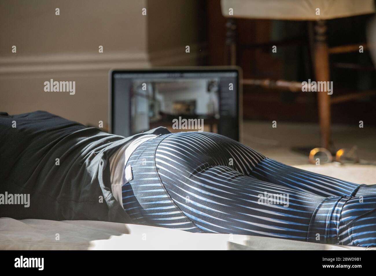 A woman has a pilates lesson over Zoom at home during the Coronavirus ...
