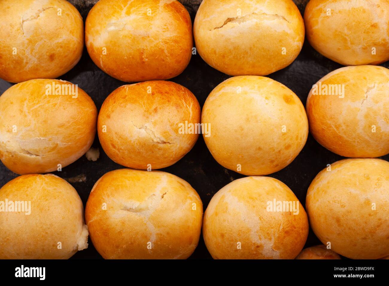 round hot baked buns with a golden crust on a baking sheet top view ...