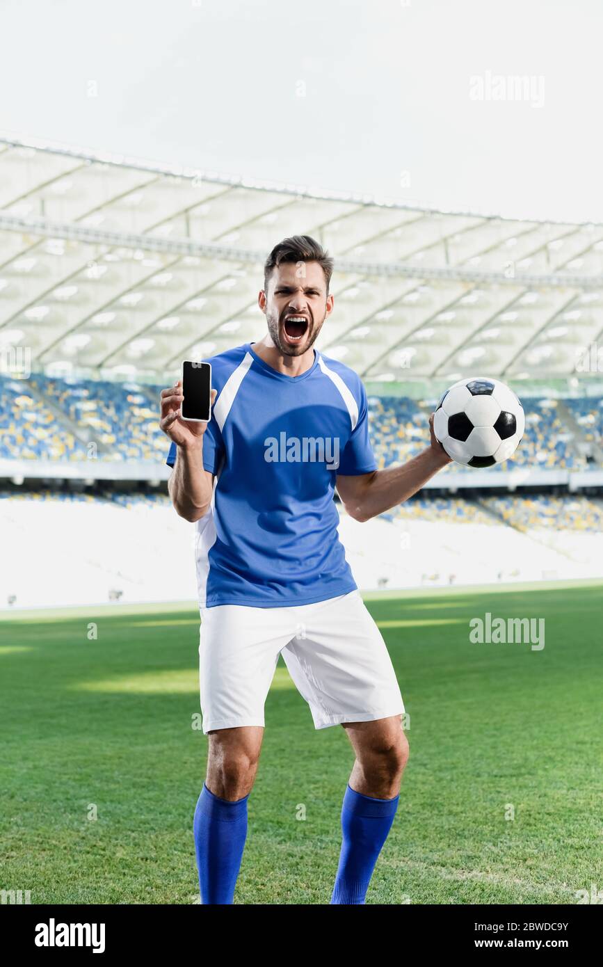 professional soccer player in blue and white uniform with ball showing ...