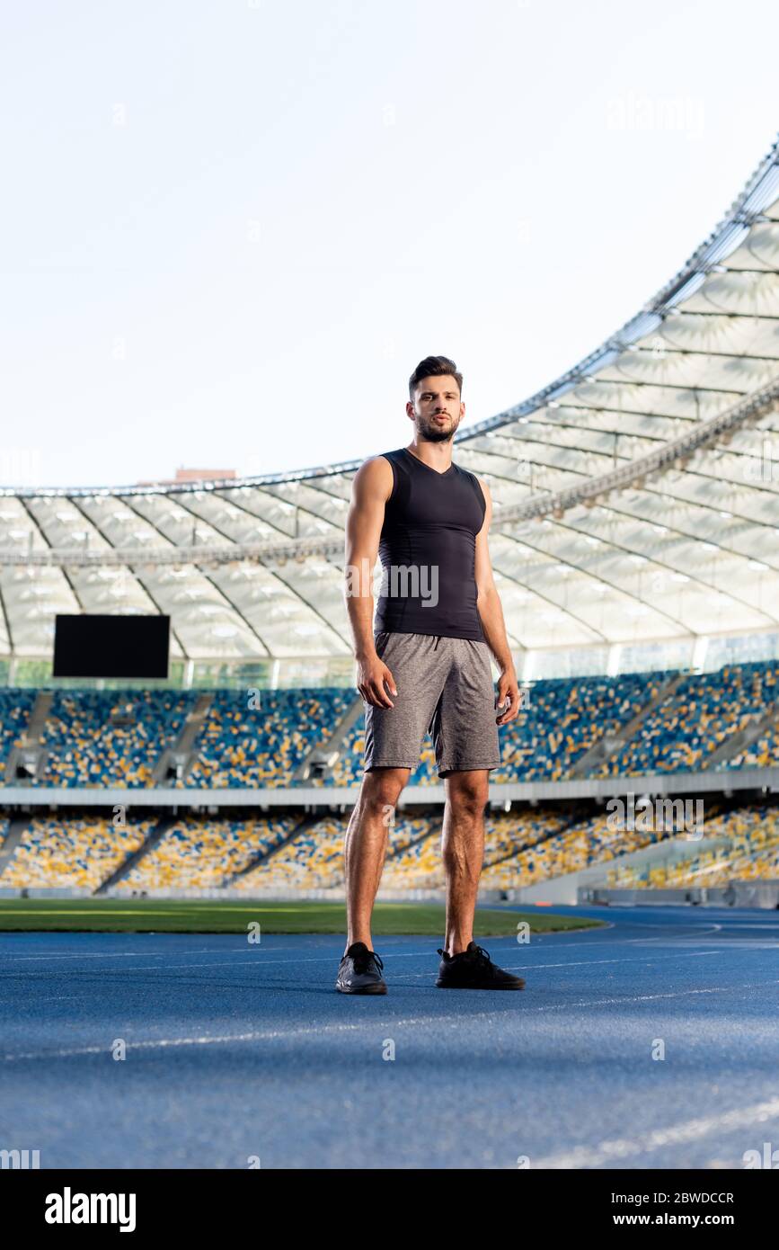 handsome young sportsman on running track at stadium Stock Photo - Alamy