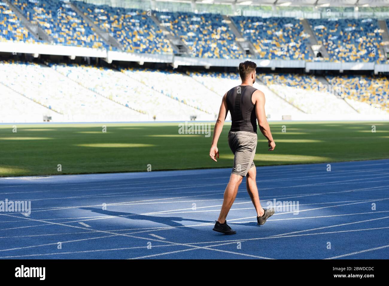 handsome runner in start position on running track at stadium Stock ...