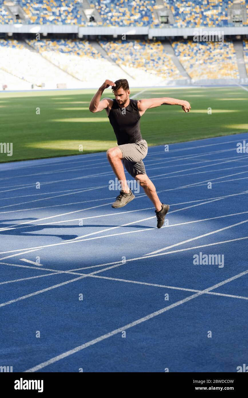 fast handsome runner exercising on running track at stadium Stock Photo ...