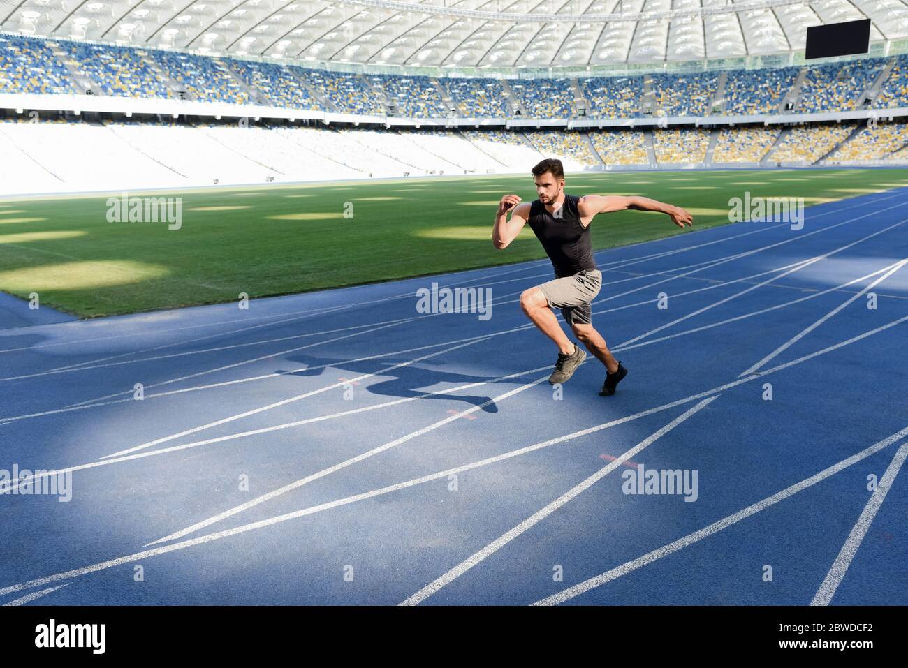 handsome runner exercising on running track at stadium Stock Photo - Alamy