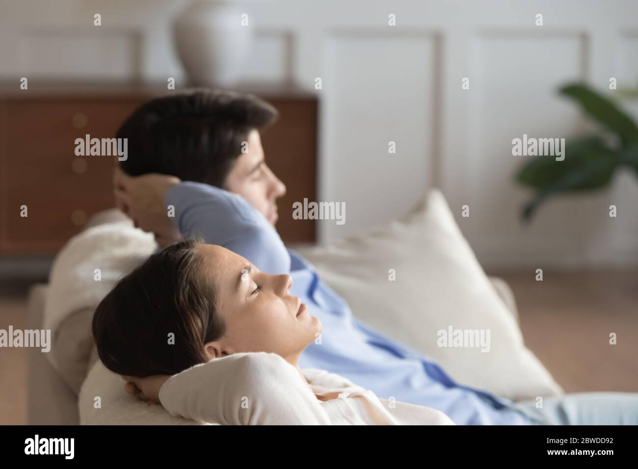 Young couple relax on couch breathing fresh air Stock Photo - Alamy