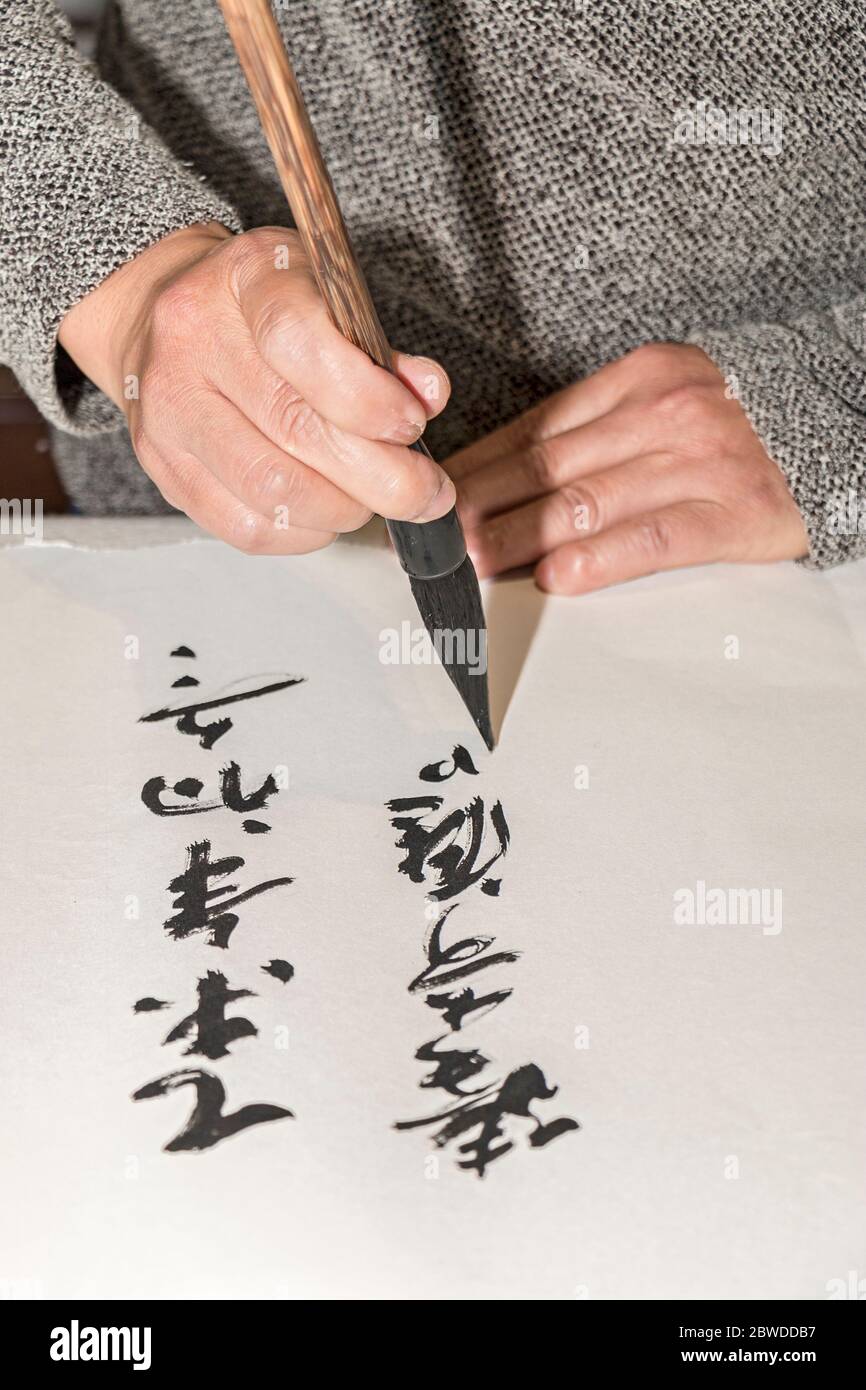 Calligrapher writing Chinese symbols on scroll at Zhen Qi Hui Art ...