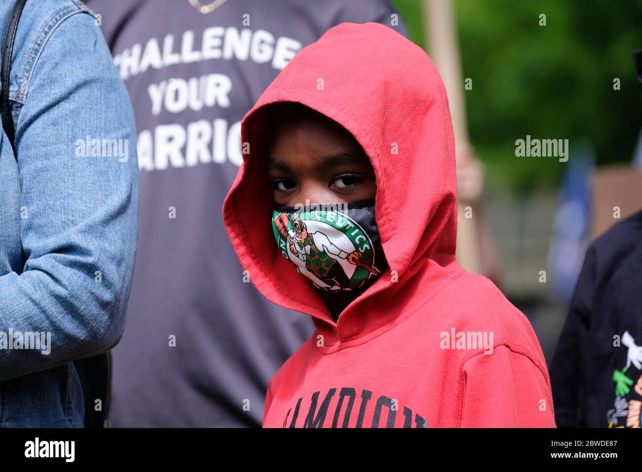A young boy wearing a face mask as a precaution against covid 19 during ...