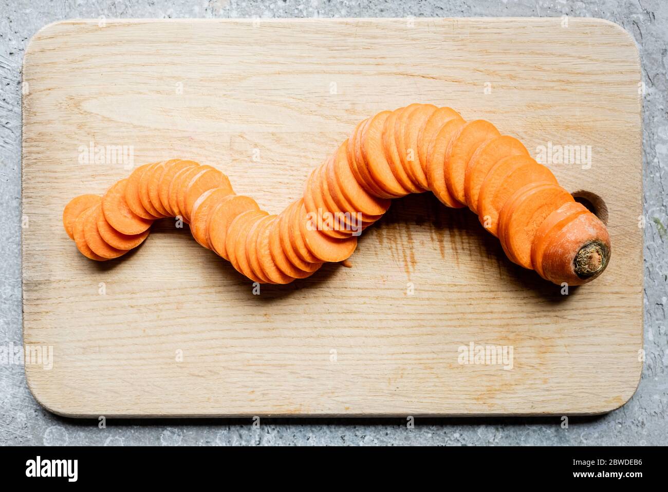 top view of fresh ripe carrot slices on wooden cutting board on ...