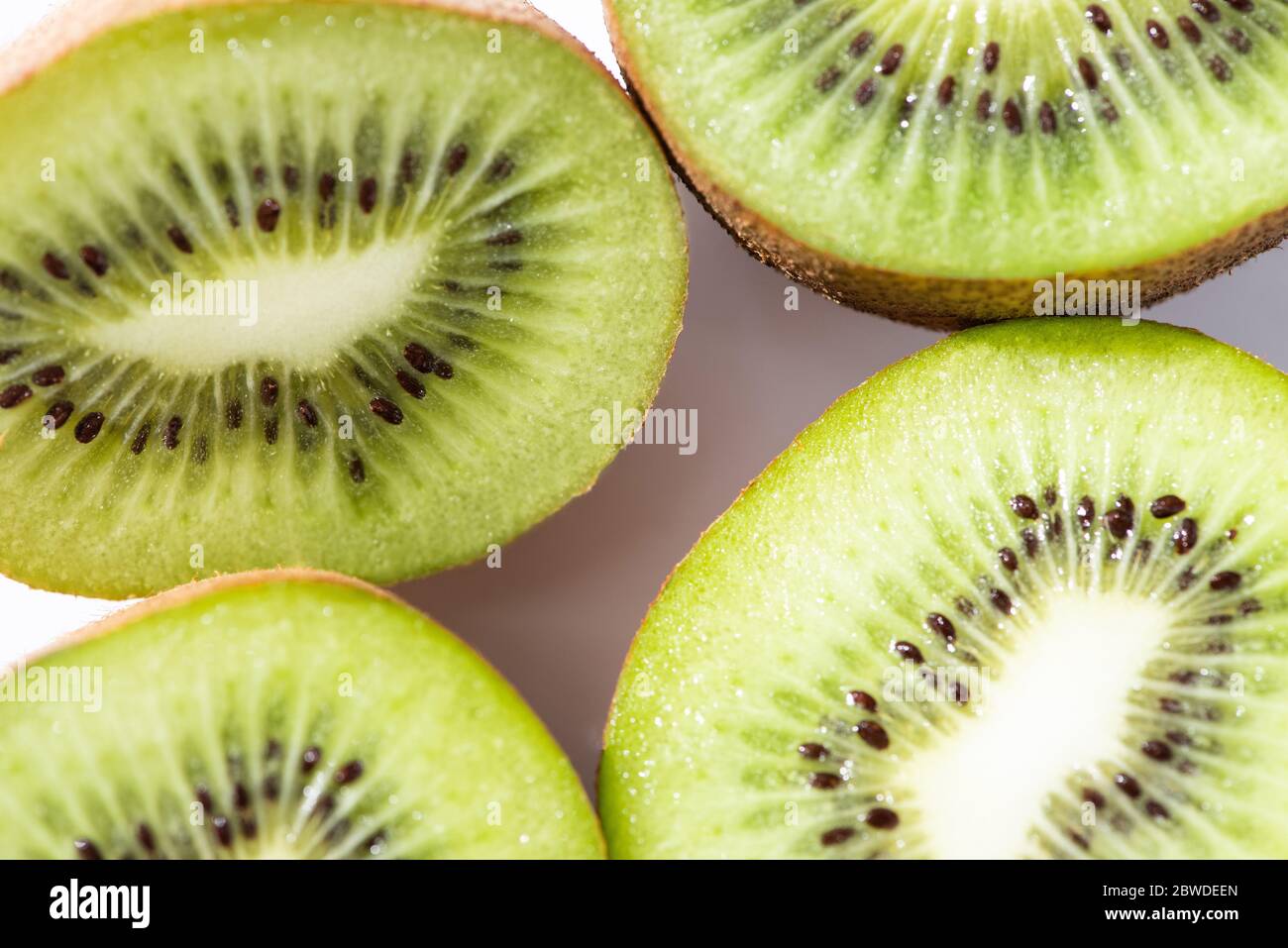 top view of green and ripe kiwifruit halves on white Stock Photo - Alamy