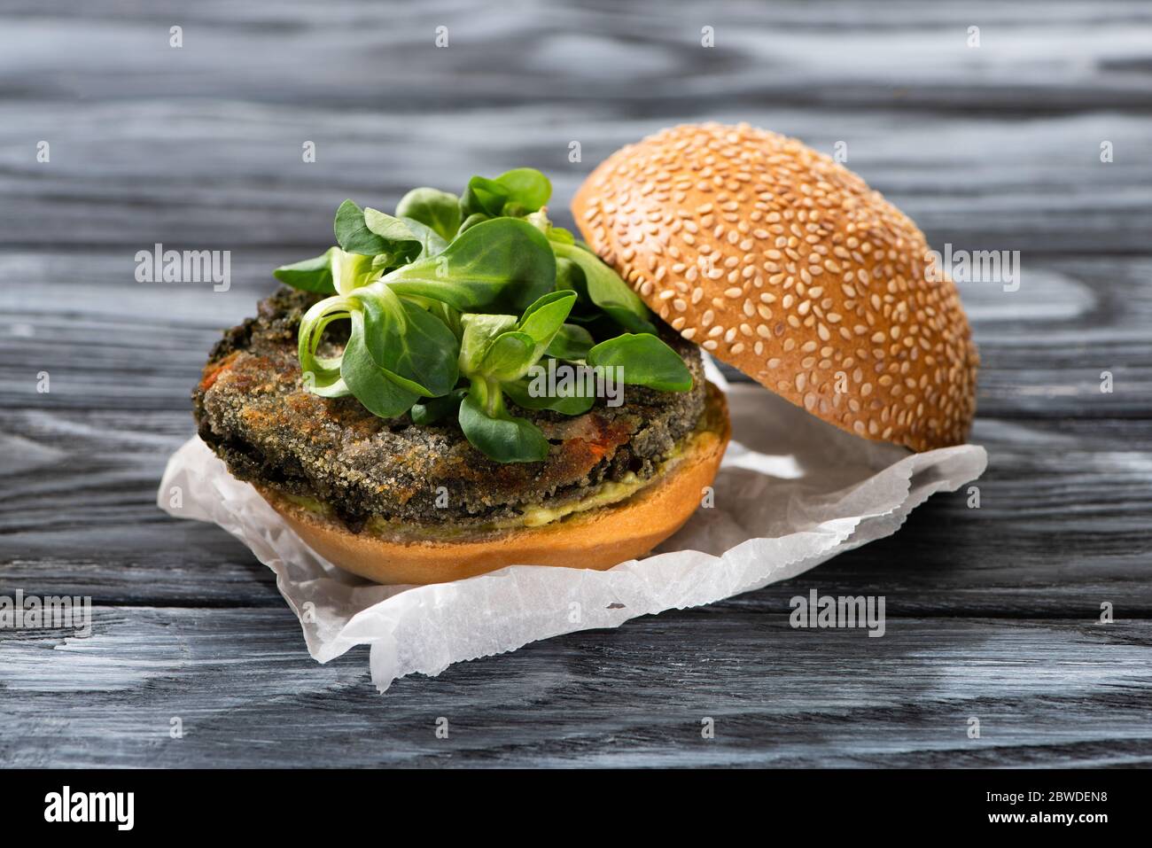 tasty vegan burger with microgreens served on wooden table Stock Photo ...