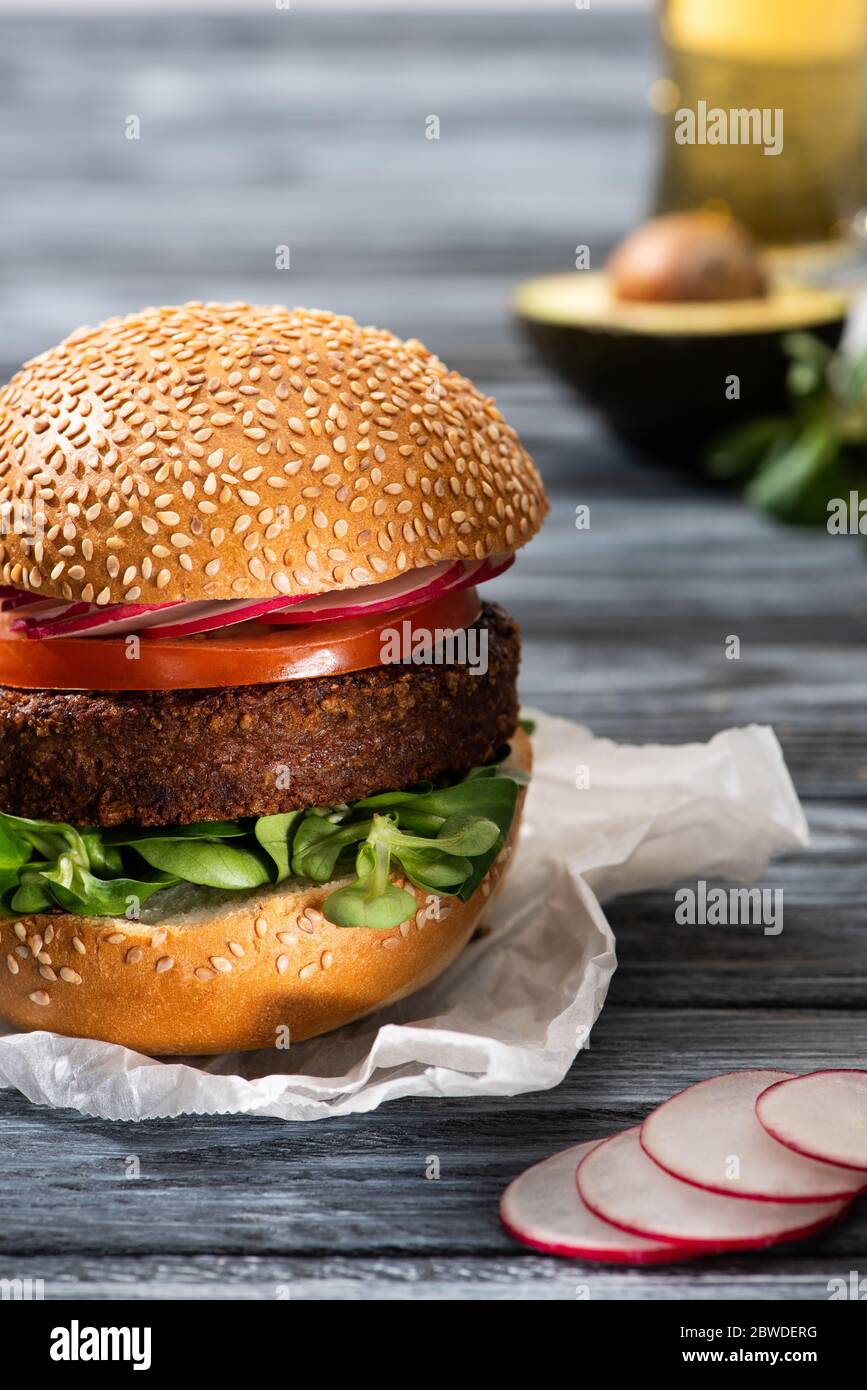selective focus of tasty vegan burger with microgreens, radish and ...