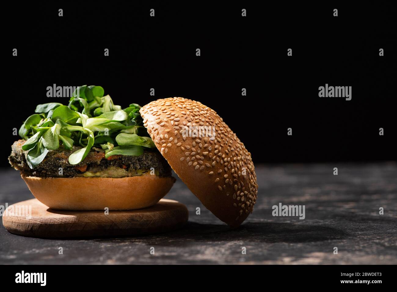 tasty vegan burger with microgreens served on wooden board isolated on ...