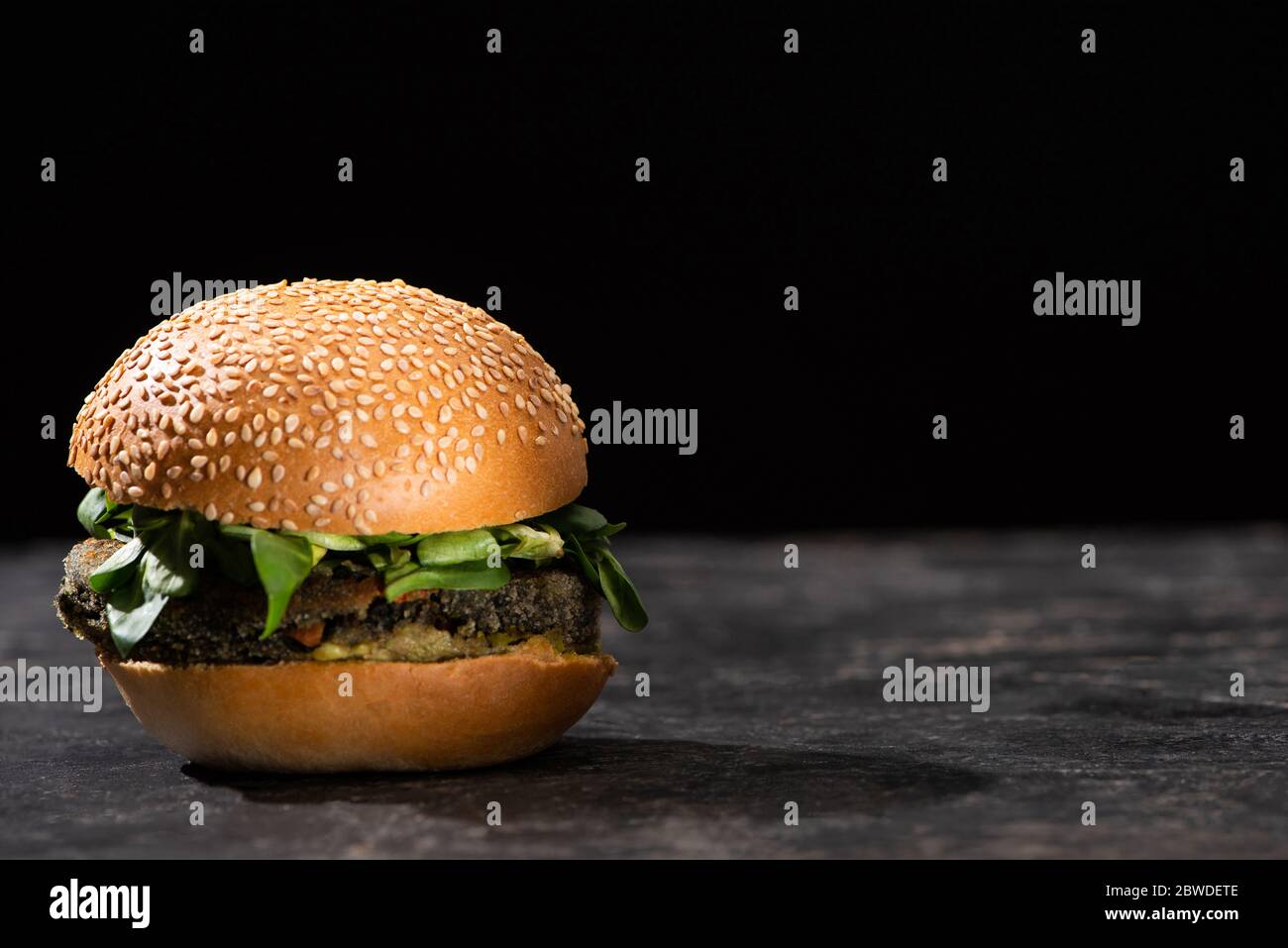 tasty vegan burger with microgreens served on textured surface isolated ...