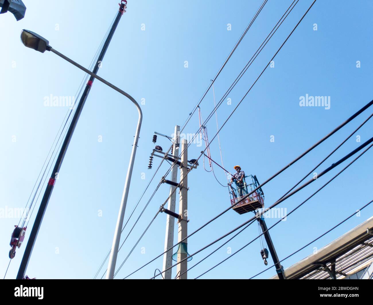 The electrician is working on the crane and the power lines on the blue ...