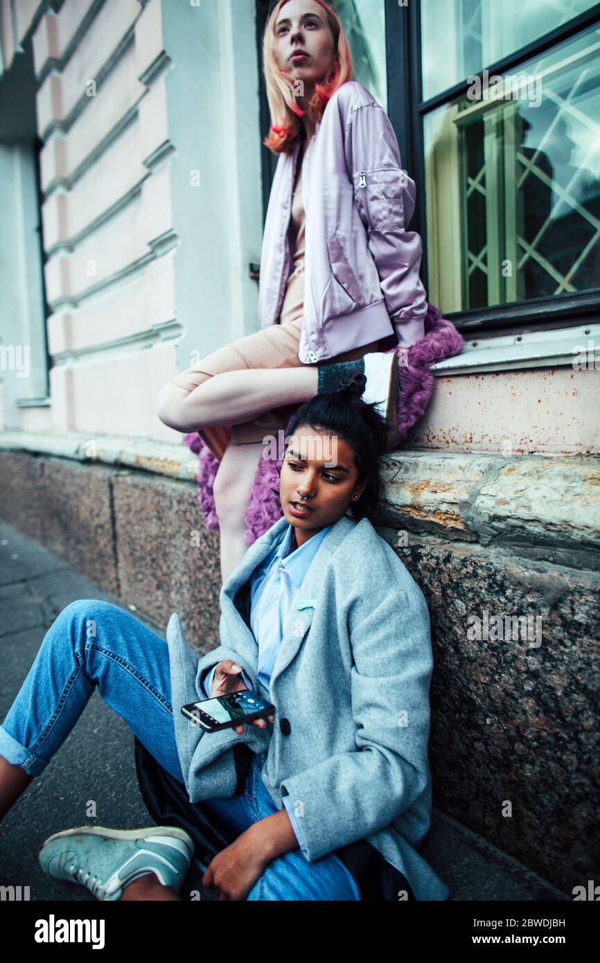 Two teenage girls infront of university building smiling, having fun ...