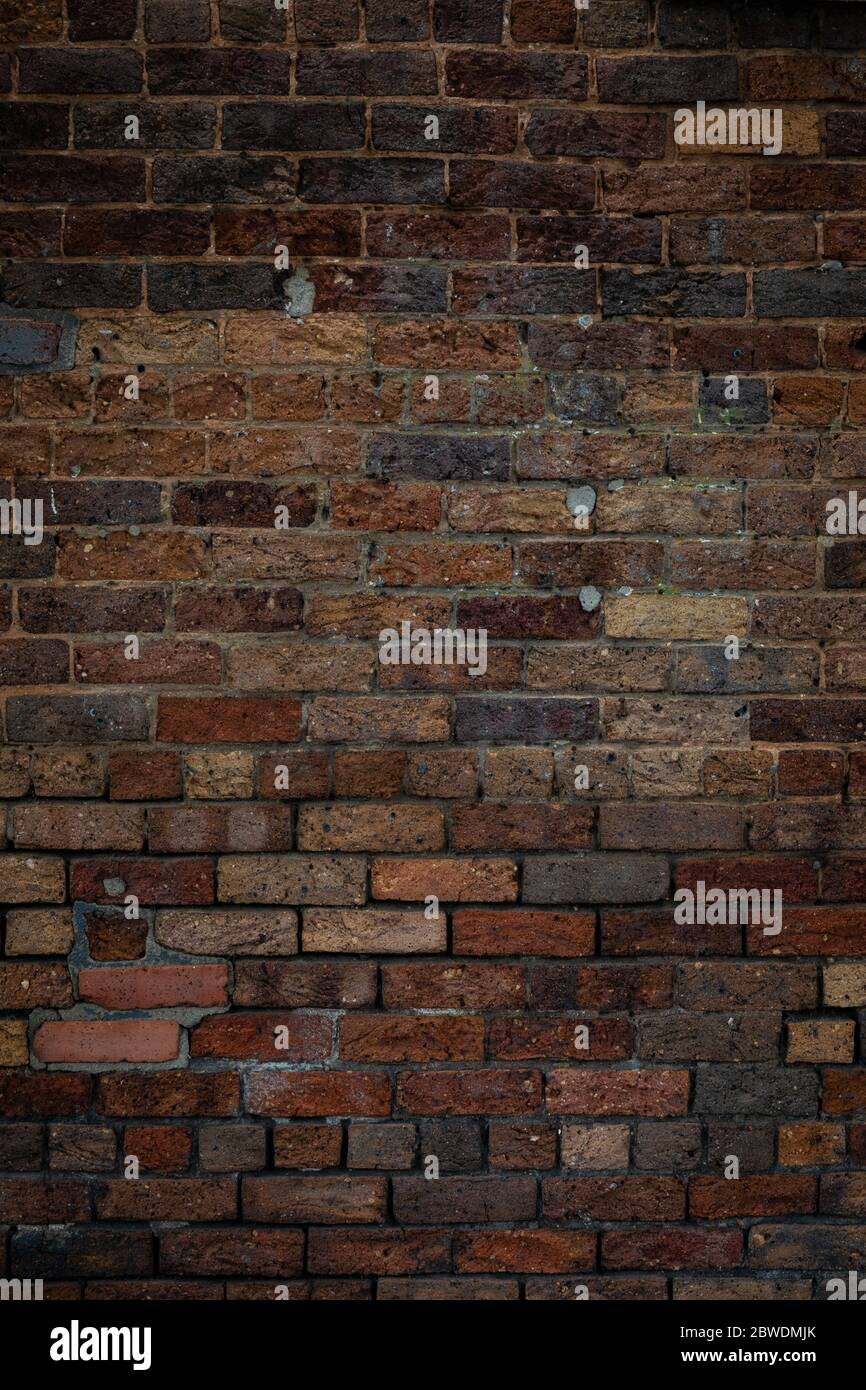 Dark brick wall texture featuring a variety of mixed bricks in many ...