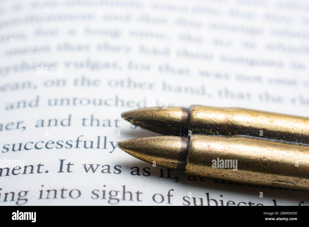 Rifle bullet model on an old book page Stock Photo - Alamy