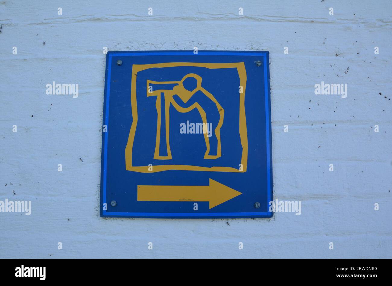blue and yellow telescope sign on white wall with arrow Stock Photo - Alamy