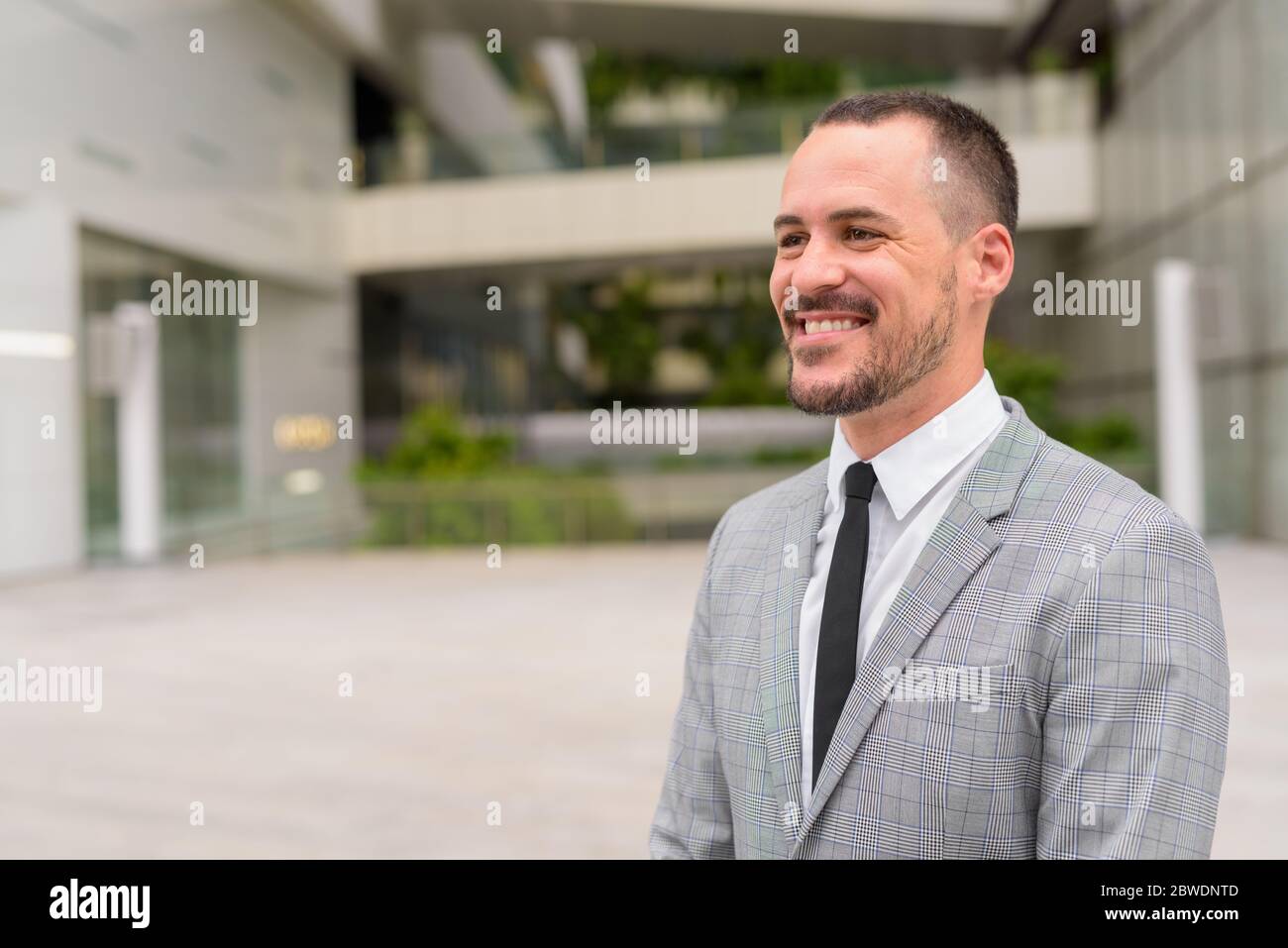 Happy Hispanic bald bearded businessman thinking in the city Stock ...