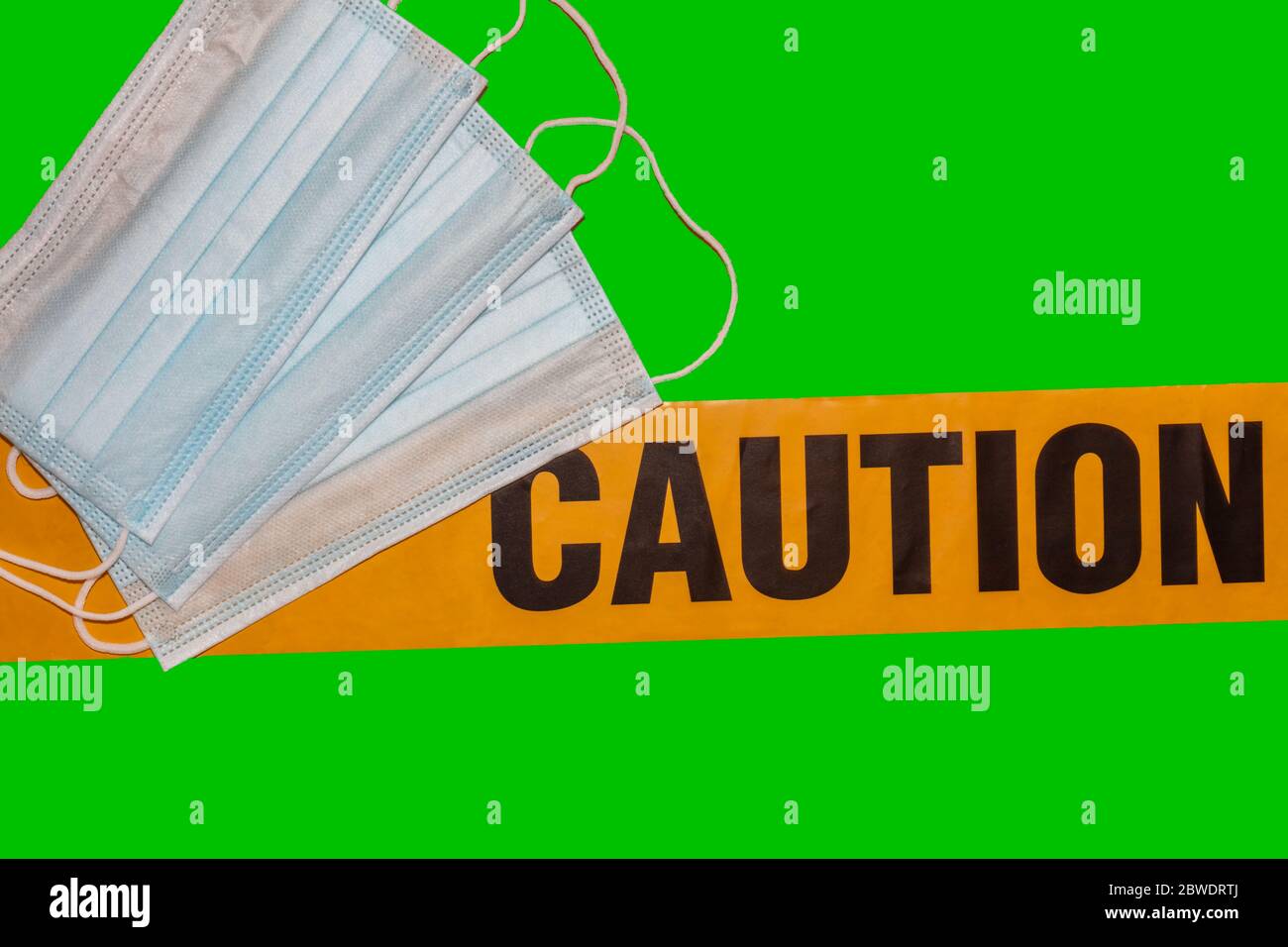 Facial protective masks on top of yellow caution tape. Isolated. Green ...