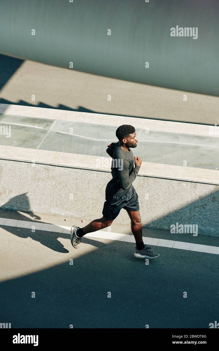 African man jogging along wall hi-res stock photography and images - Alamy