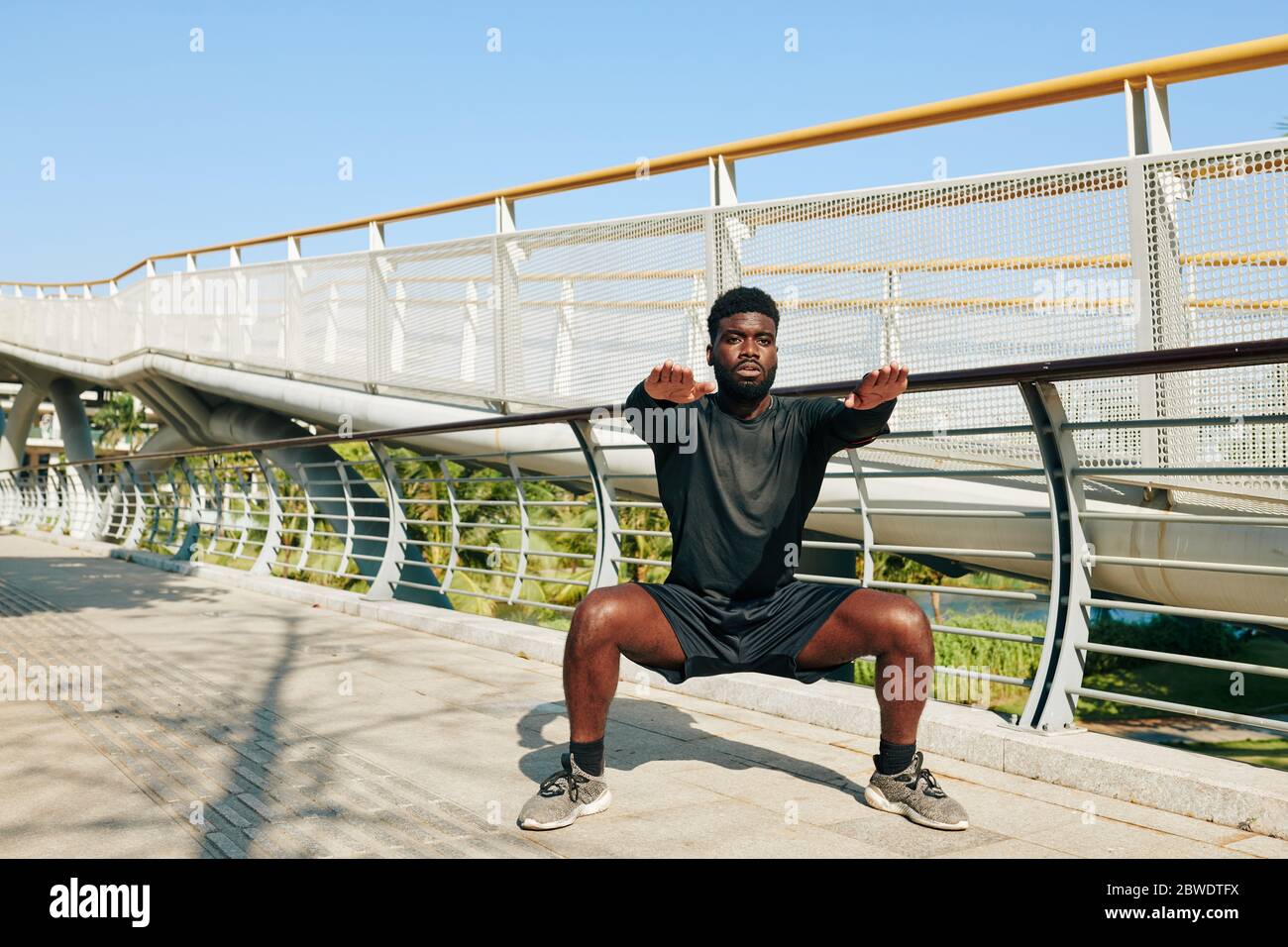 Handsome fit young Black man putting arms straight out in front of him ...