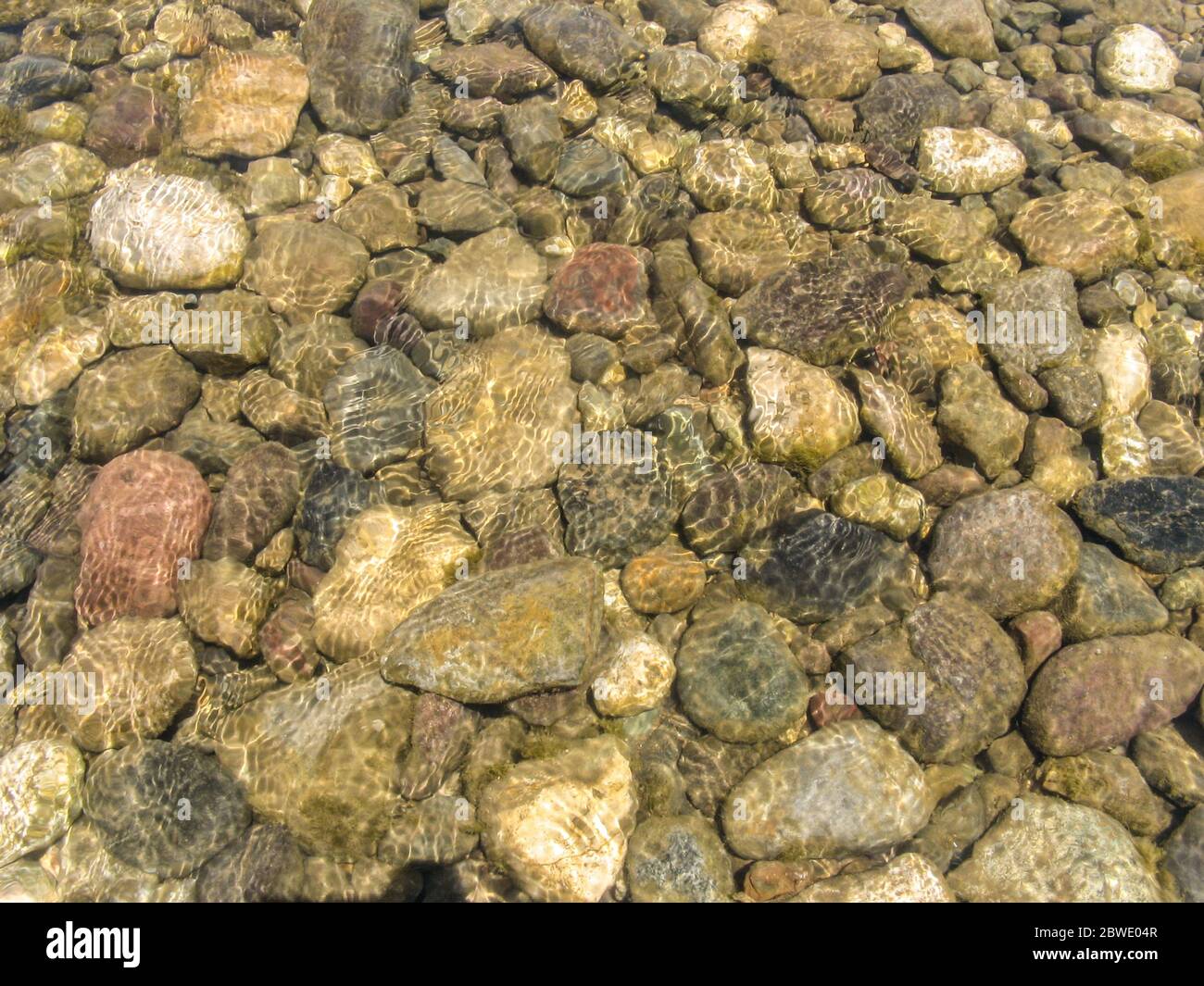 Clear water of river under sunlight. River stones in the clear river ...