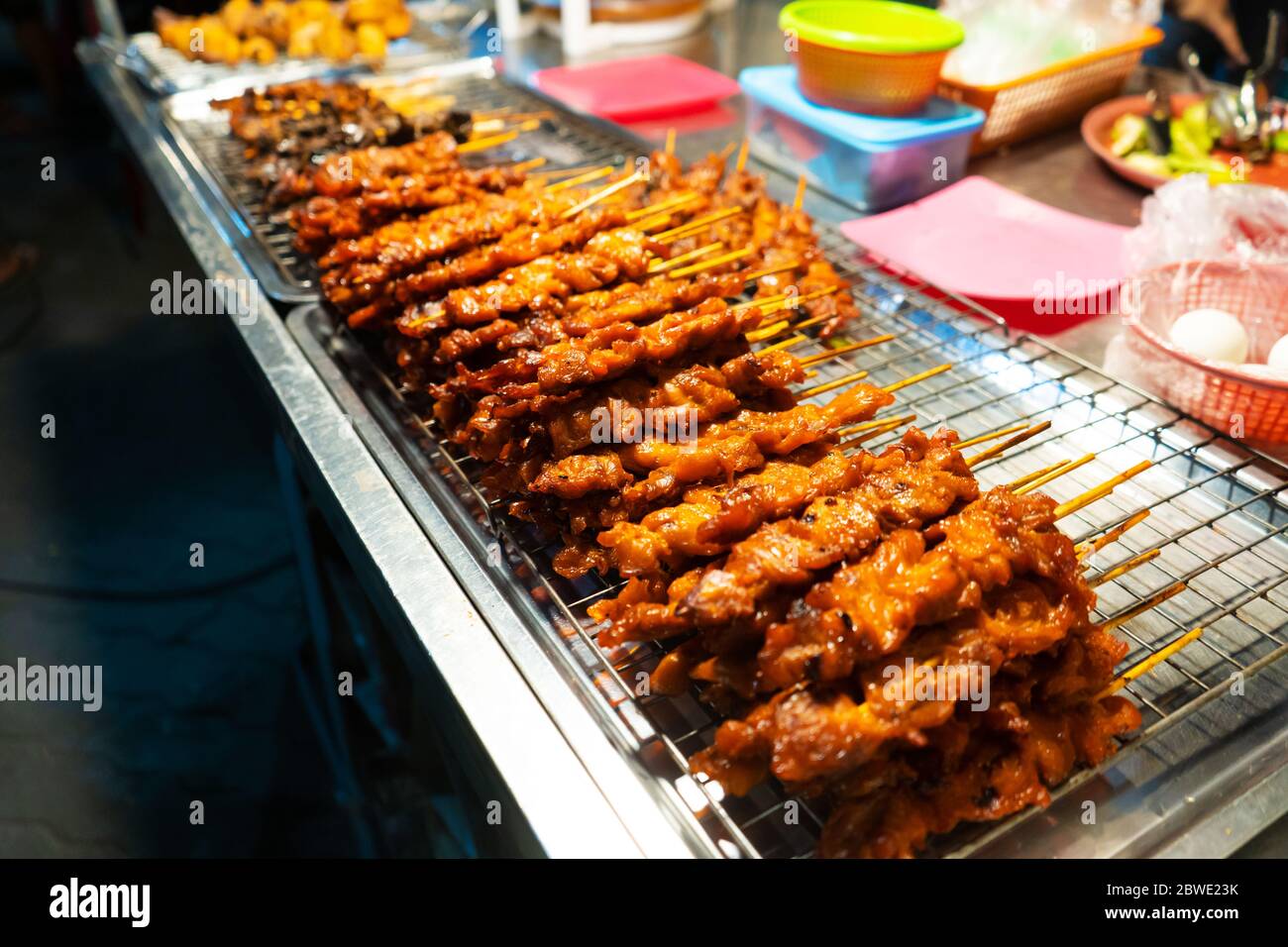 Asian food. A counter with mini kebabs of chicken skin and meat at a ...