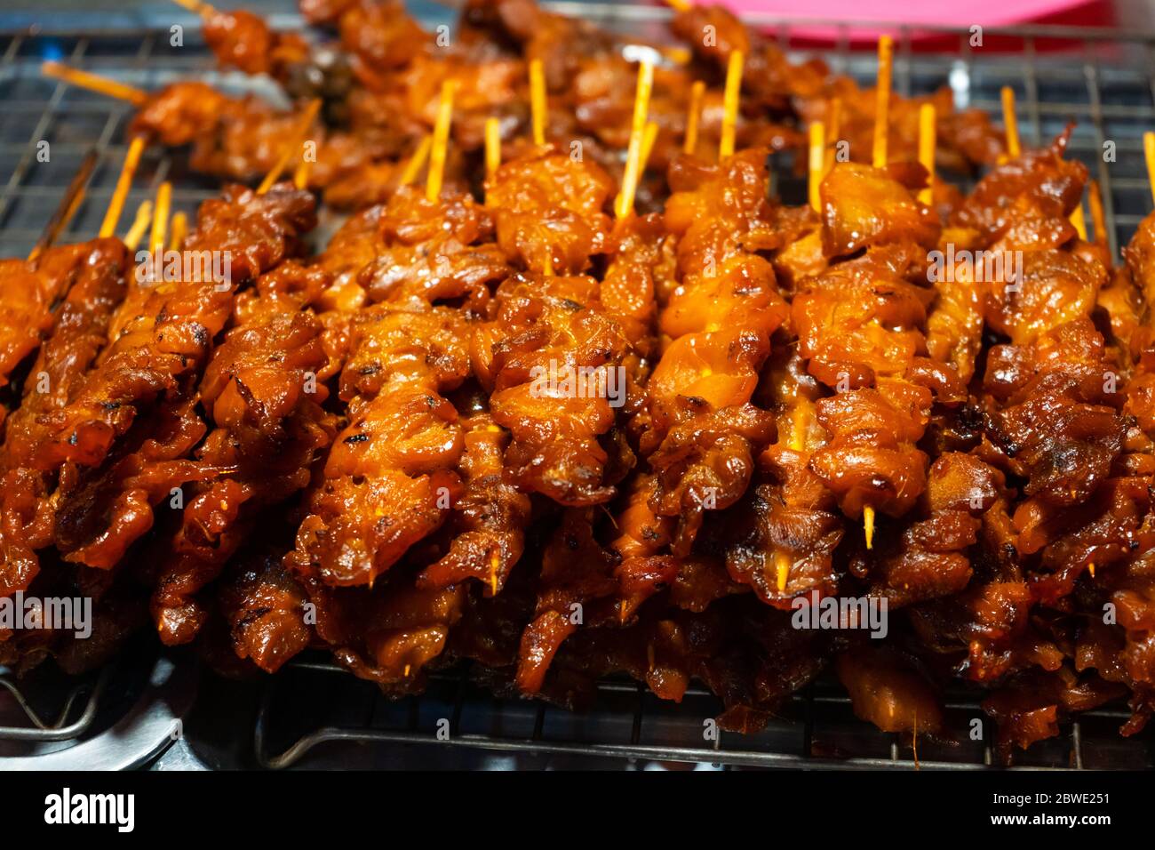 Asian food. A counter with mini kebabs of chicken skin and meat at a ...