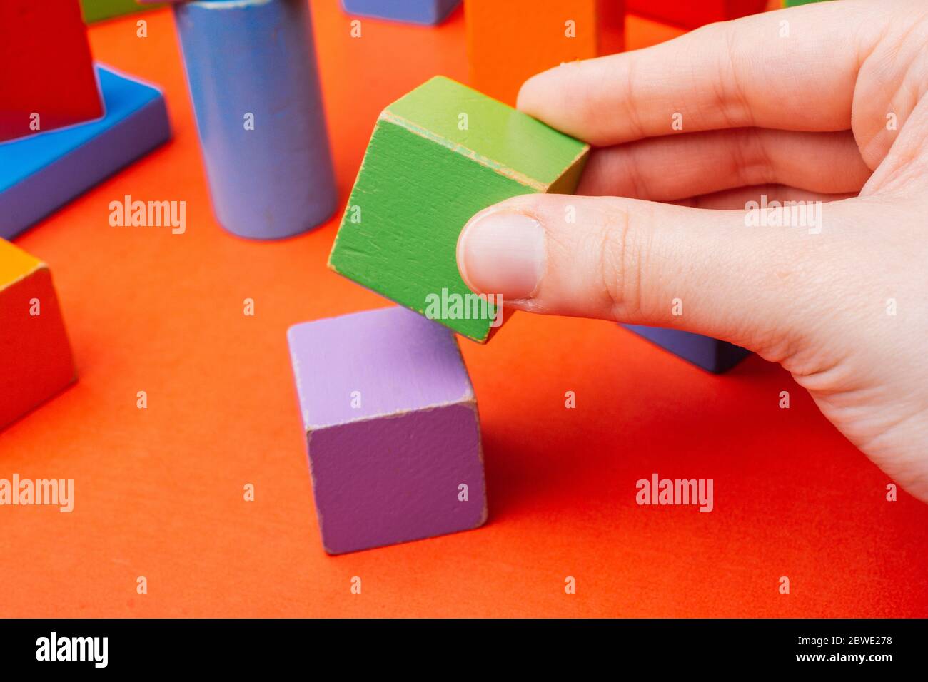 hand building tower with colorful building blocks Stock Photo - Alamy