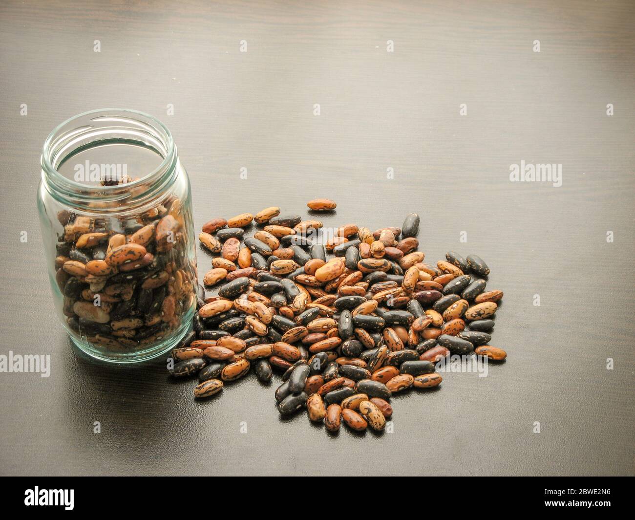 Short leg bean seeds (Phaseolus vulgaris) in a glass jar on the wooden ...