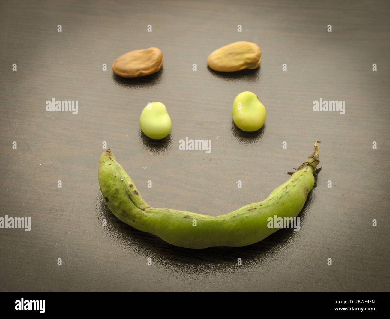 Close up of smile broad beans with wooden background. Make smiley shape ...