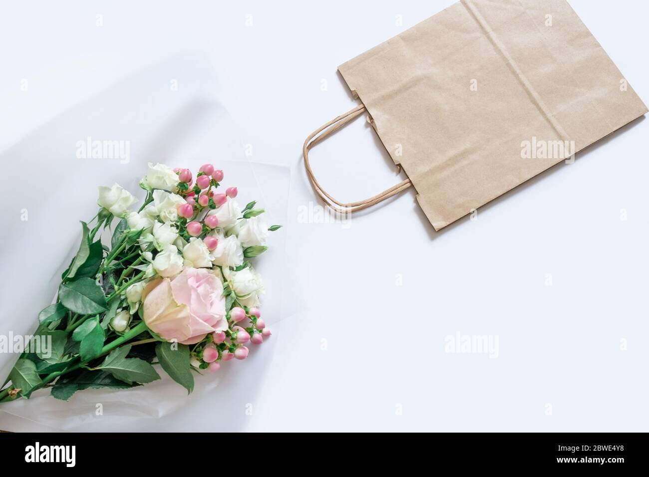 Bouquet of Pink Flowers and Craft Paper Bag on the White background ...