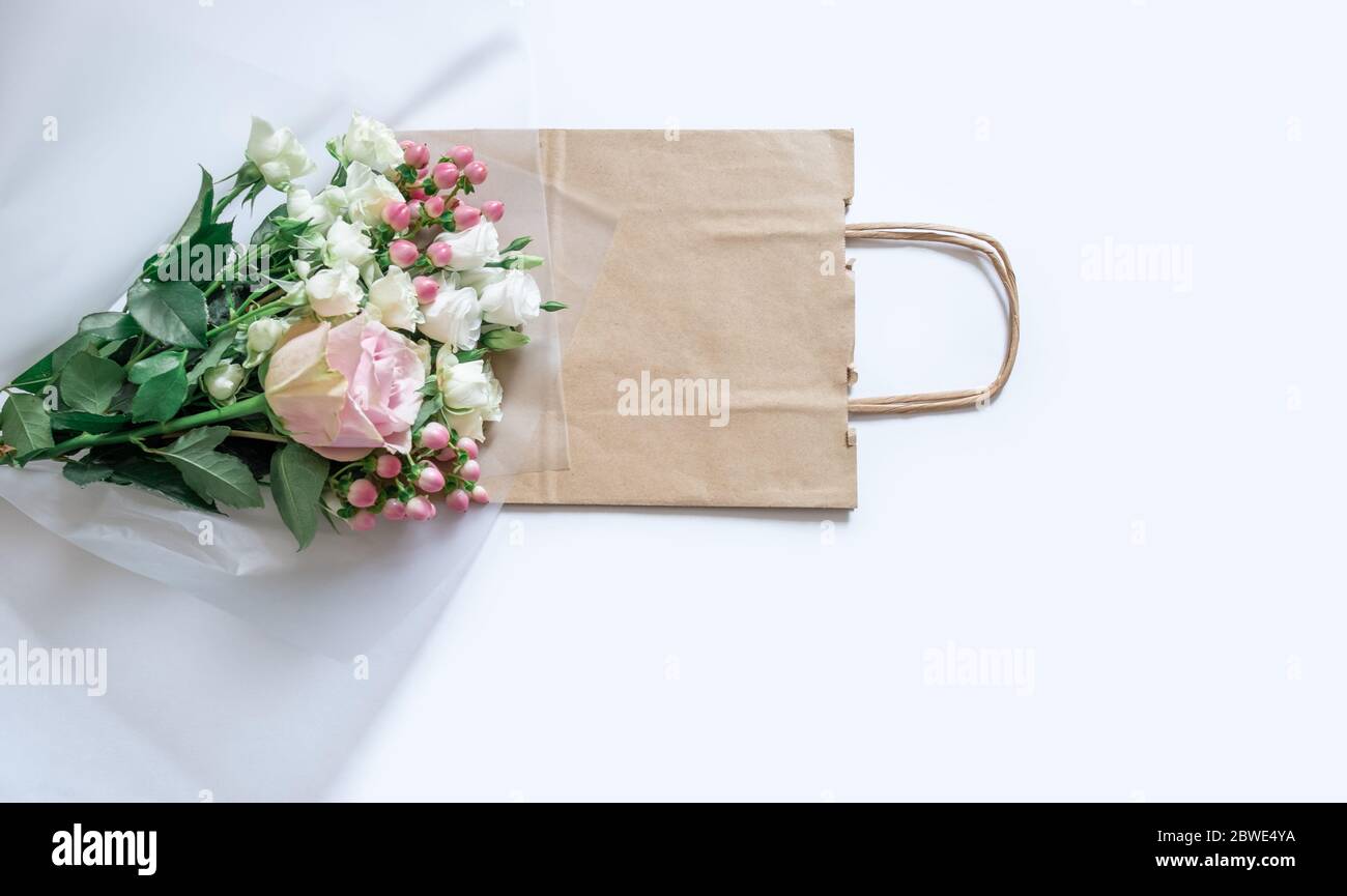 Bouquet of Pink Flowers and Craft Paper Bag on the White background ...
