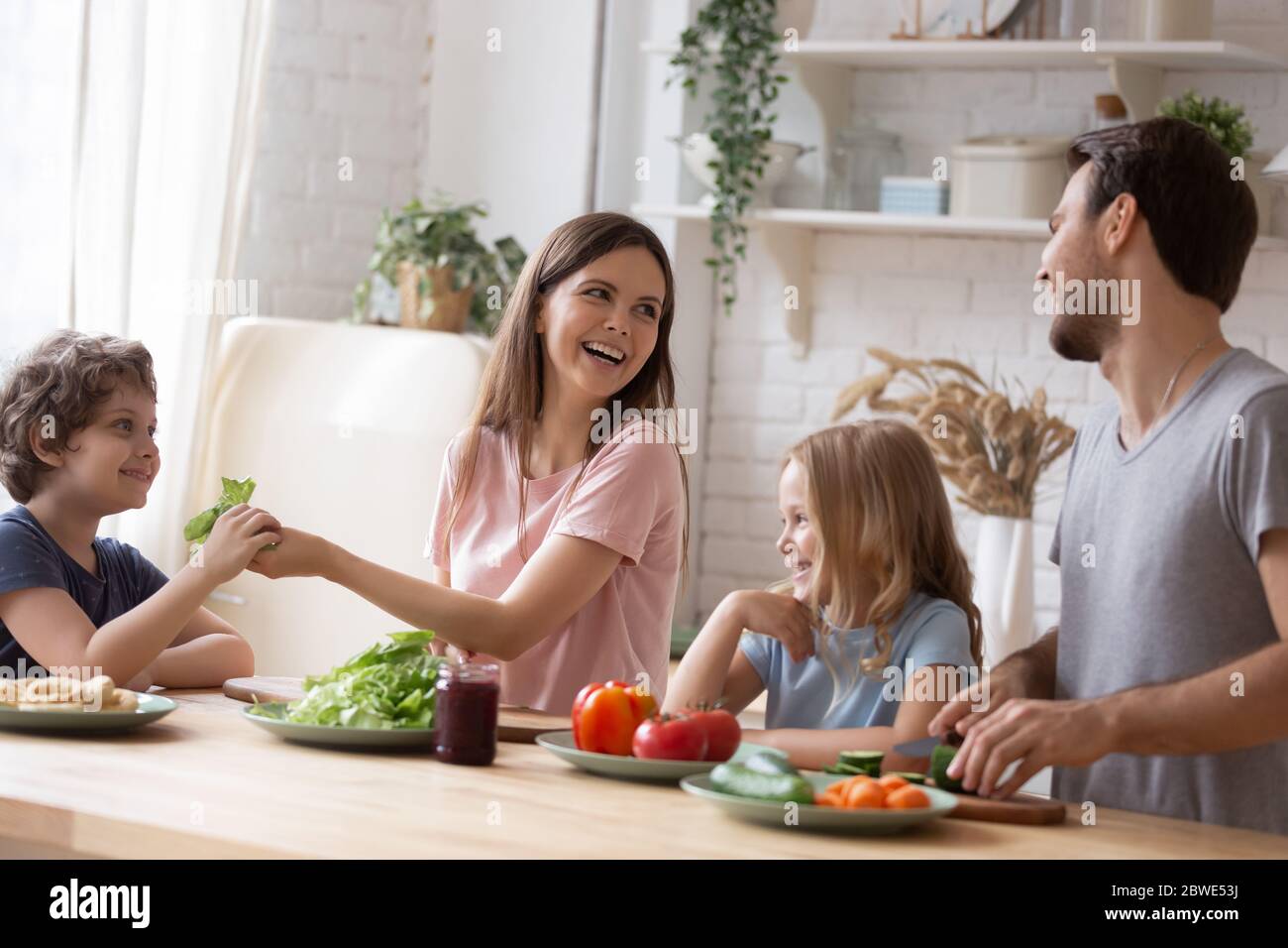 Young parents with small kids cooking together at home Stock Photo - Alamy