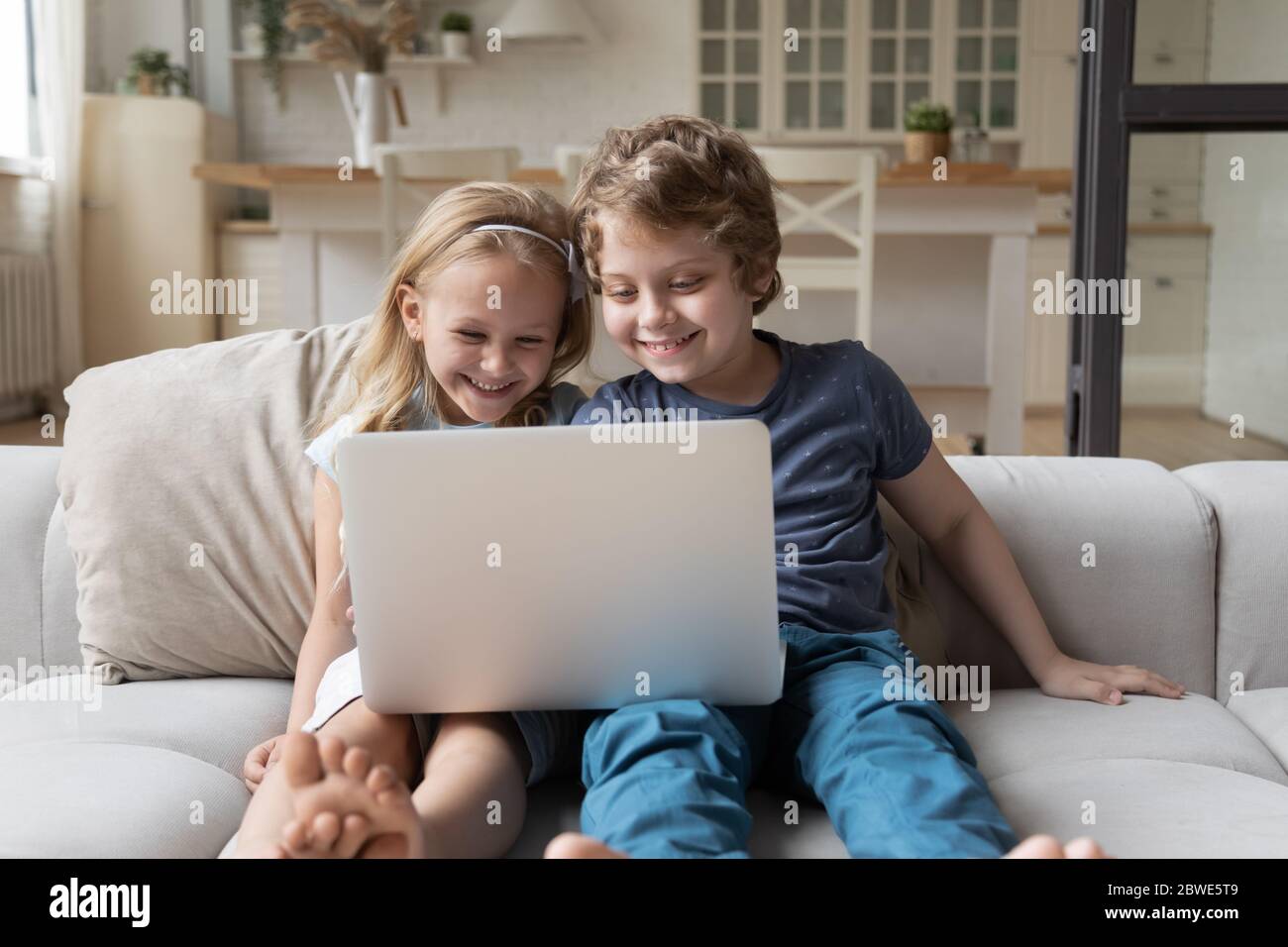 Smiling smart siblings have fun using laptop together Stock Photo - Alamy