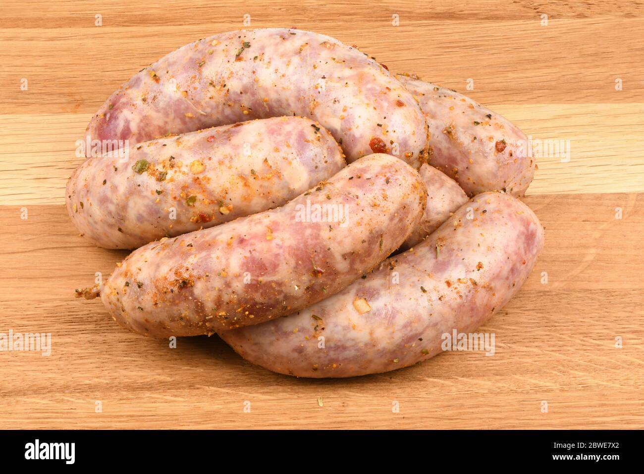 Fresh raw pork sausage isolated on wood background. High resolution ...