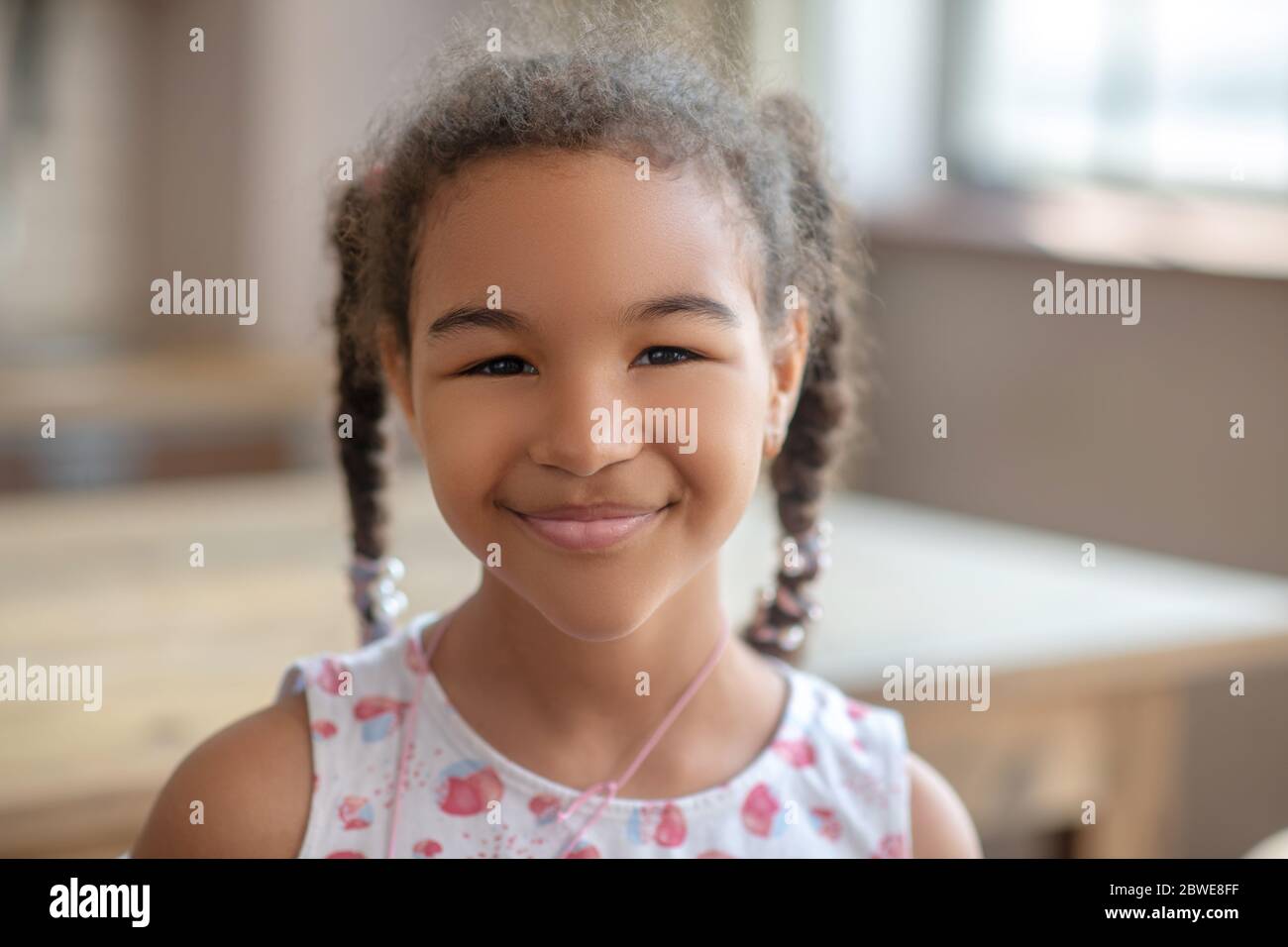 Cute curly-haired girl smiling and looking happy Stock Photo - Alamy Cute curly-haired girl smiling and looking happy Stock Photo - Alamy