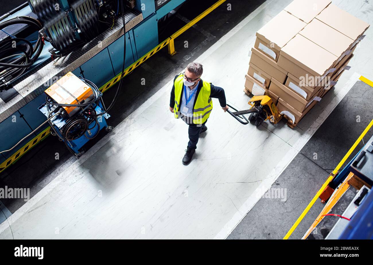 Aerial view of man worker with protective mask working in industrial ...