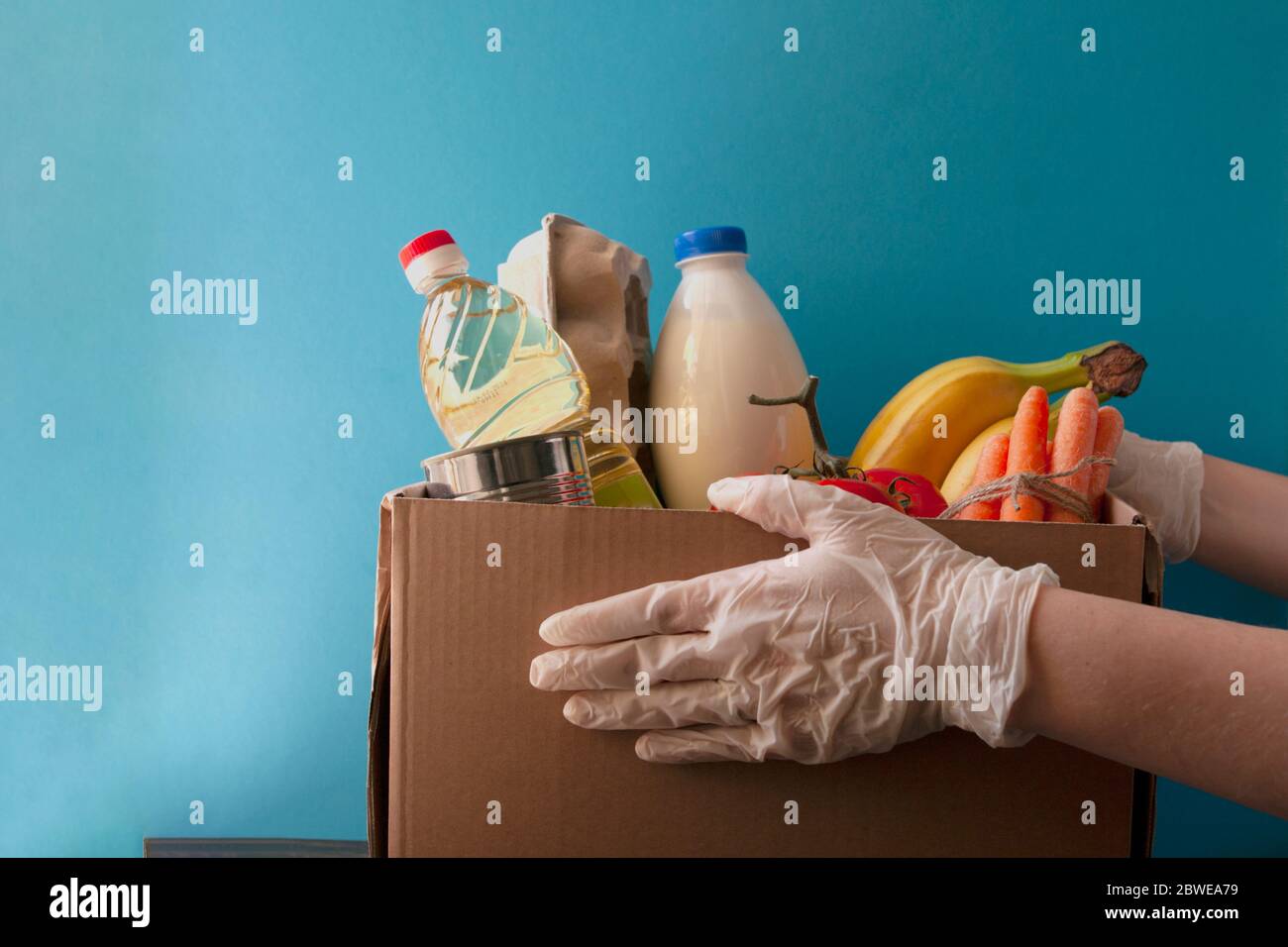 Food delivery. Hands in gloves holding box with grocery Stock Photo - Alamy