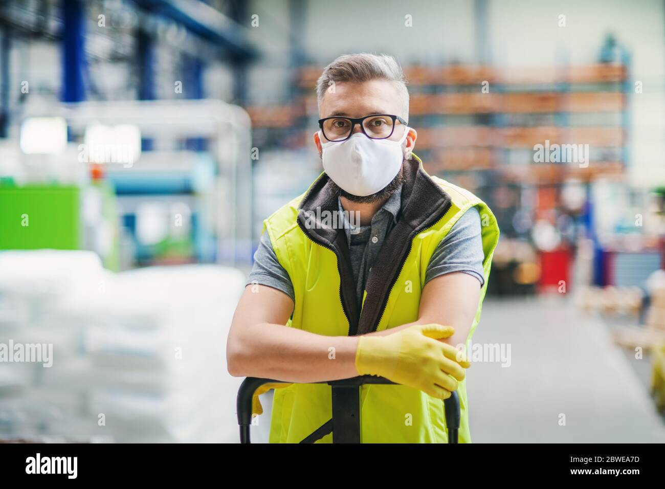 Man worker with protective mask standing in industrial factory or ...