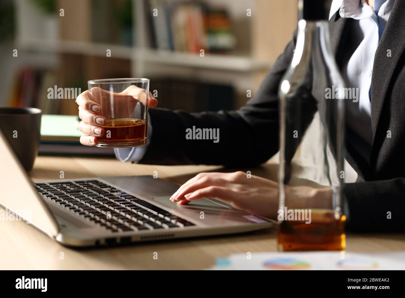 Close up of entrepreneur woman hands drinking alcohol working on laptop ...