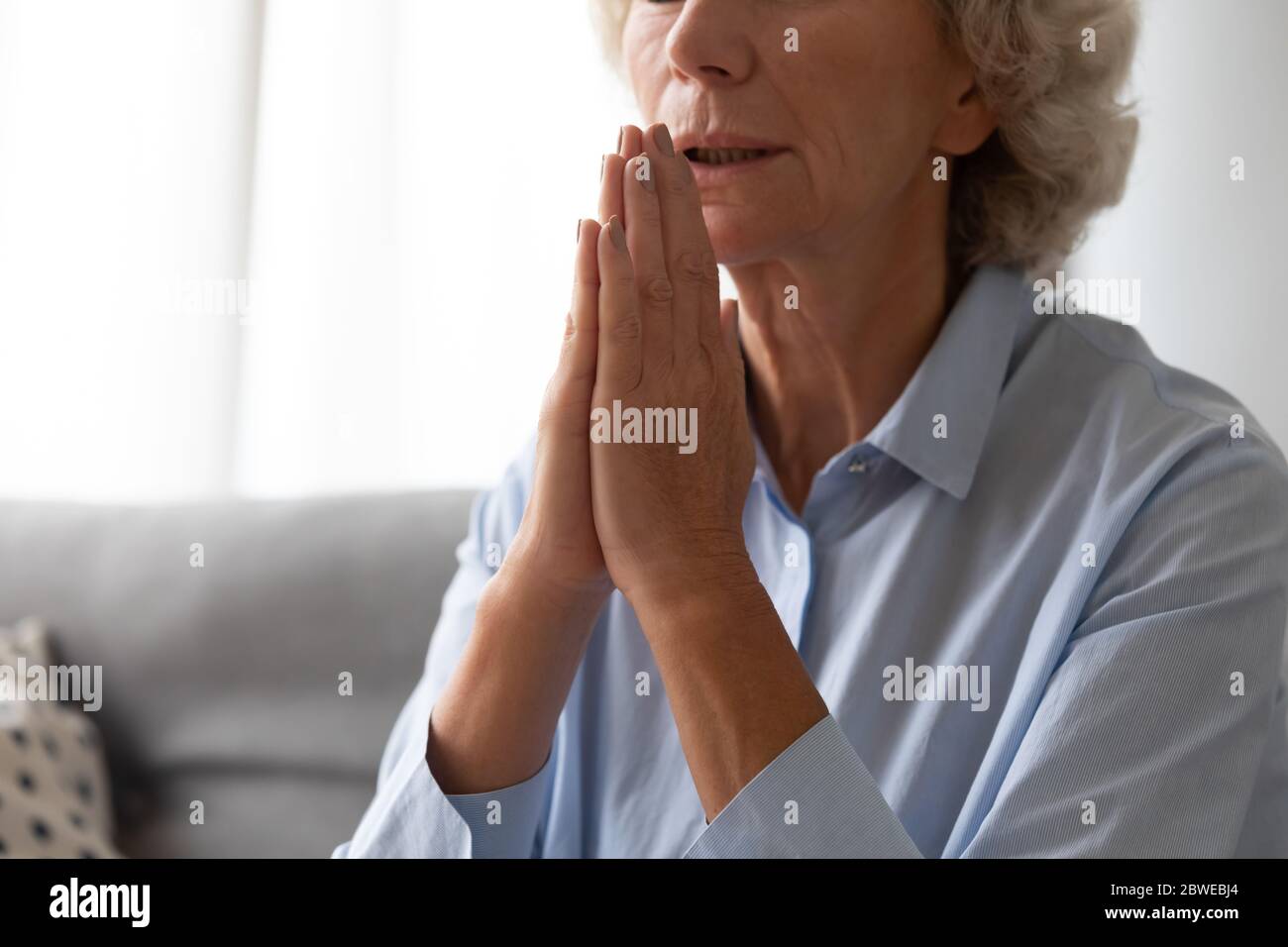 Old woman folded palms together praying indoors Stock Photo - Alamy