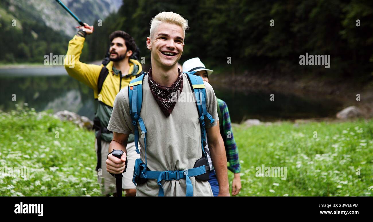 Group of friends hiking together outdoors exploring the wilderness and ...
